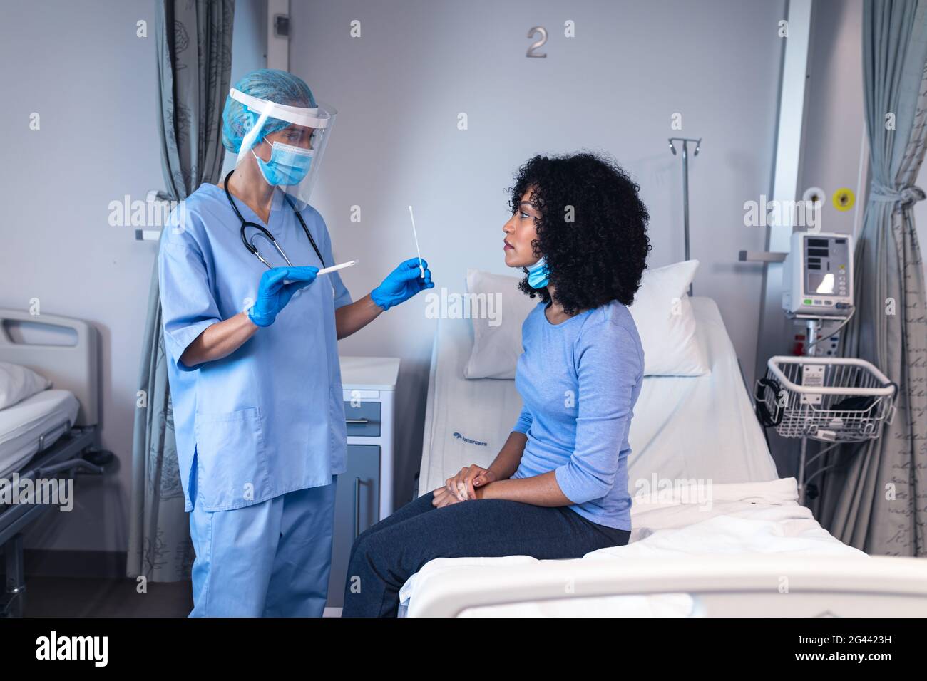 African american female patient tested with swab test by female doctor ...