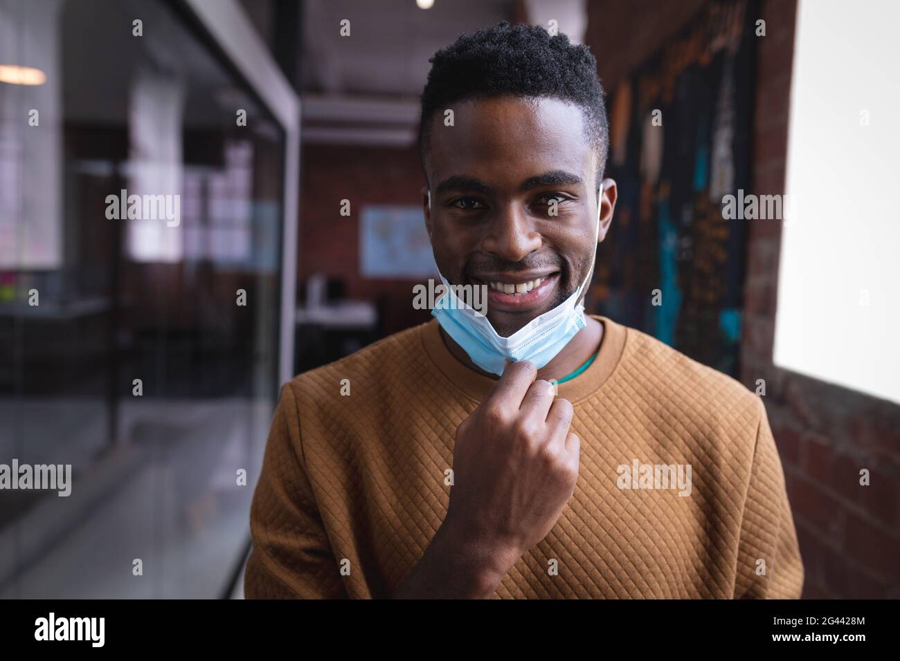 Portrait of happy african american businessman taking off face mask ...