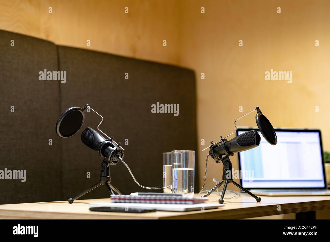 Office desk with microphones, documents, laptop computer, glasses of ...