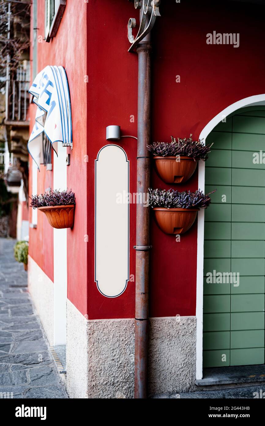 Vertical blank sign on a beautiful building with blooming flowerpots ...
