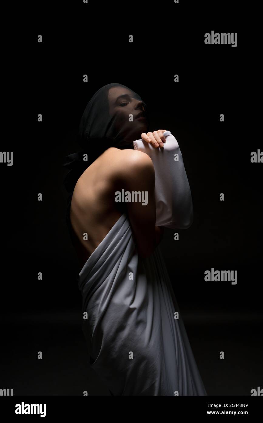 Woman wrapped in cloth outstretching arms in studio Stock Photo - Alamy