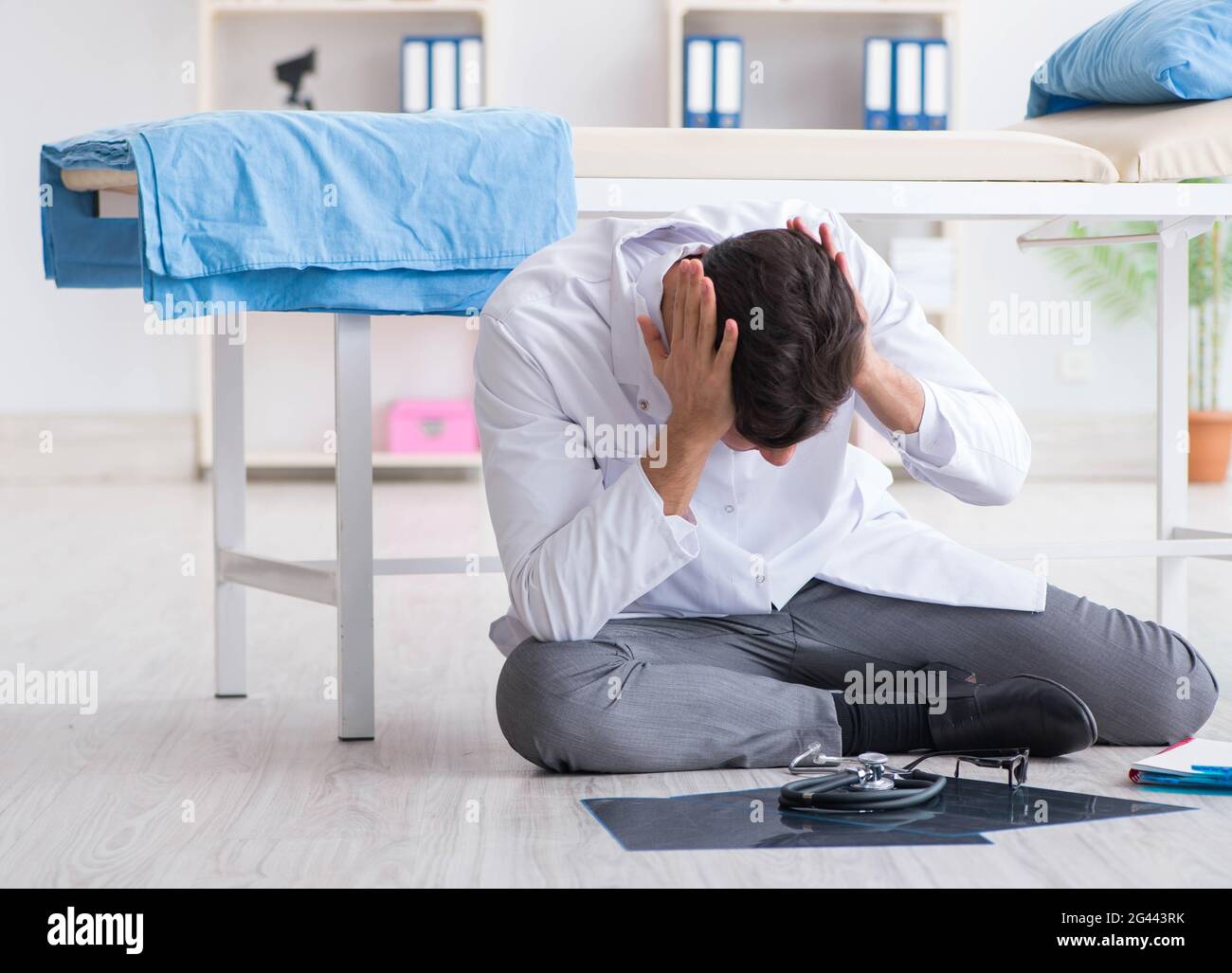 Doctor sitting on the floor in hospital Stock Photo - Alamy
