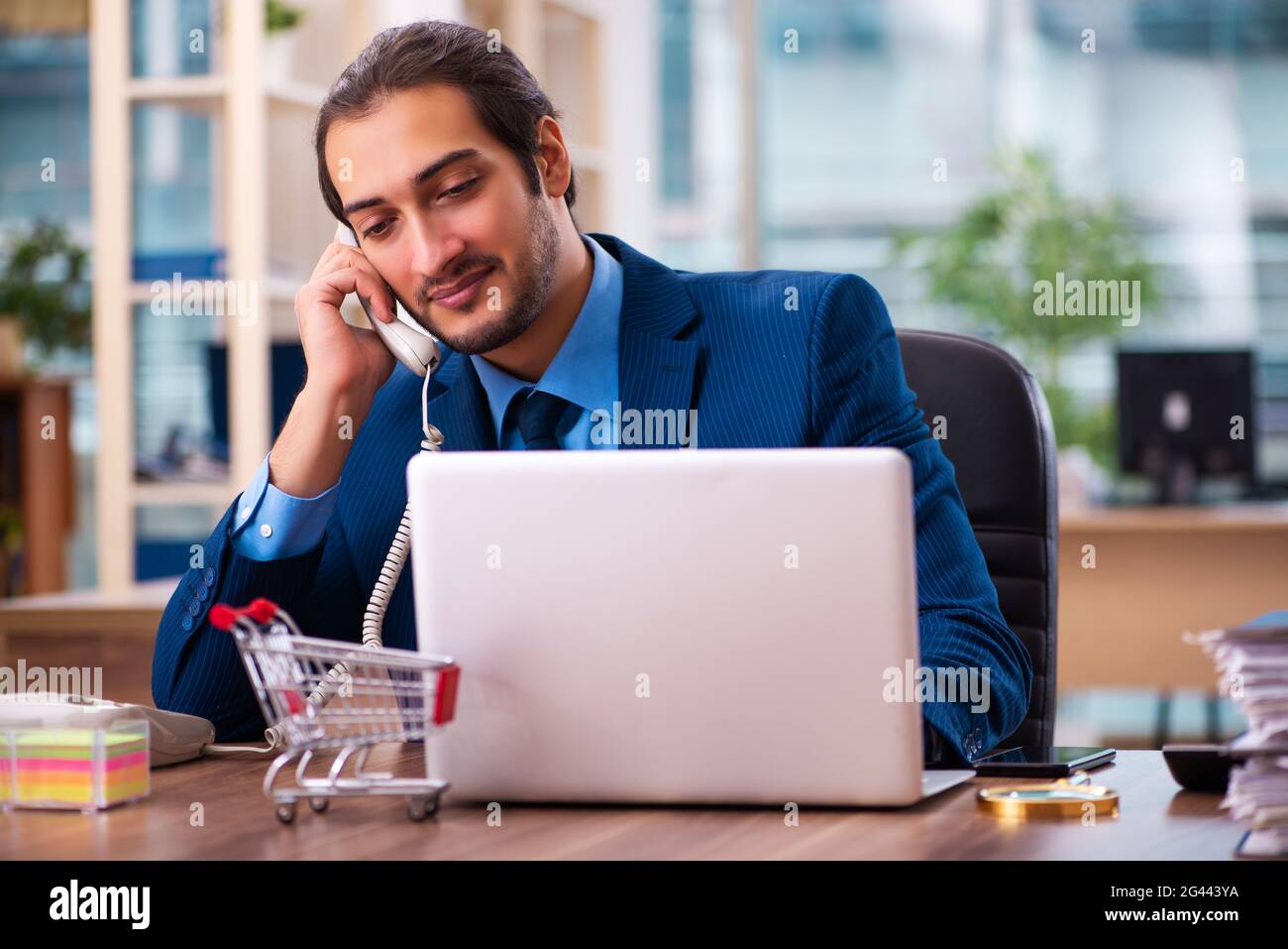 Young male employee in ecommerce concept Stock Photo - Alamy