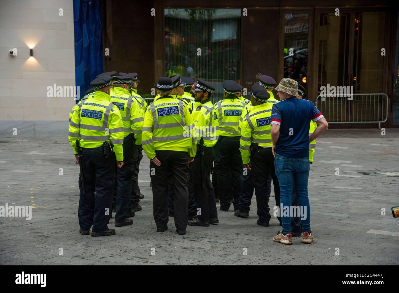 A football fan stands behind a group of Police officers in Leicester ...