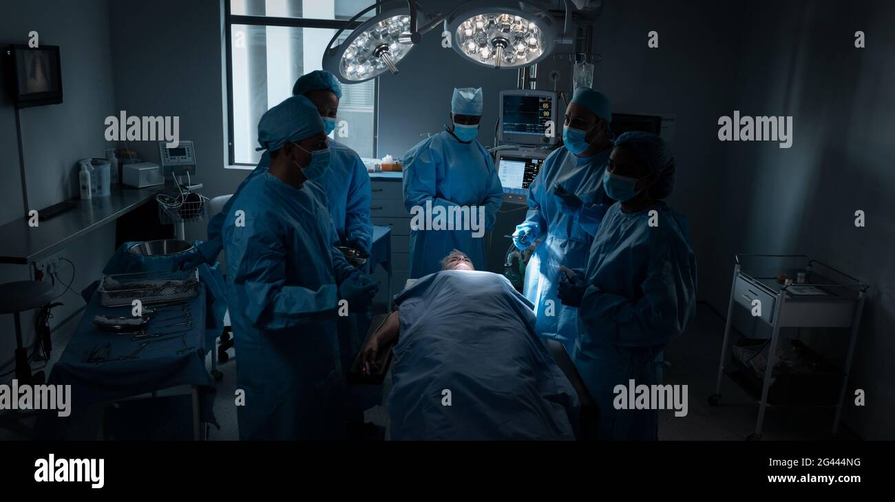 Diverse male and female doctors wearing face masks and surgical ...