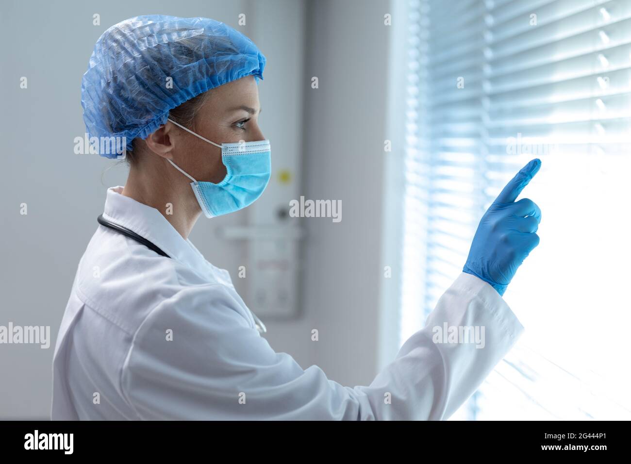 Caucasian female doctor wearing face mask using virtual interactive ...