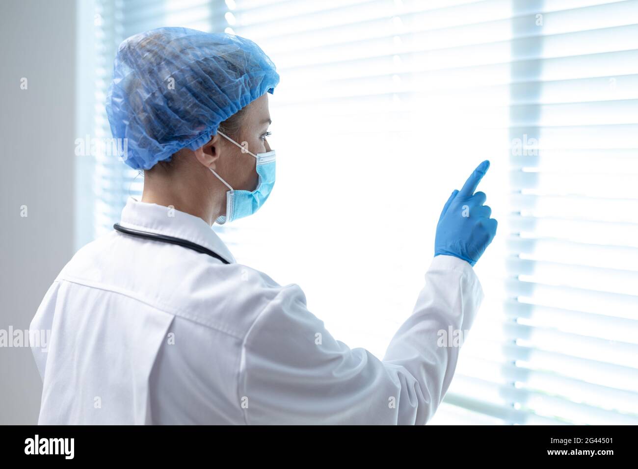 Caucasian female doctor wearing face mask using virtual interactive ...