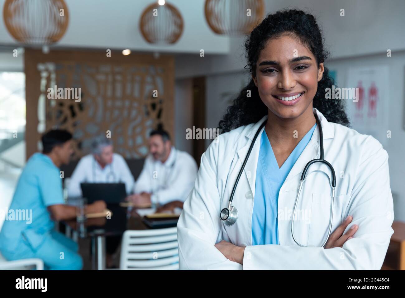 Portrait of smiling asian female doctor, with colleagues in discussion ...