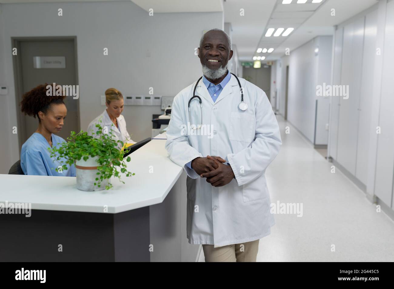 Portrait of african american male doctor standing in hospital corridor ...