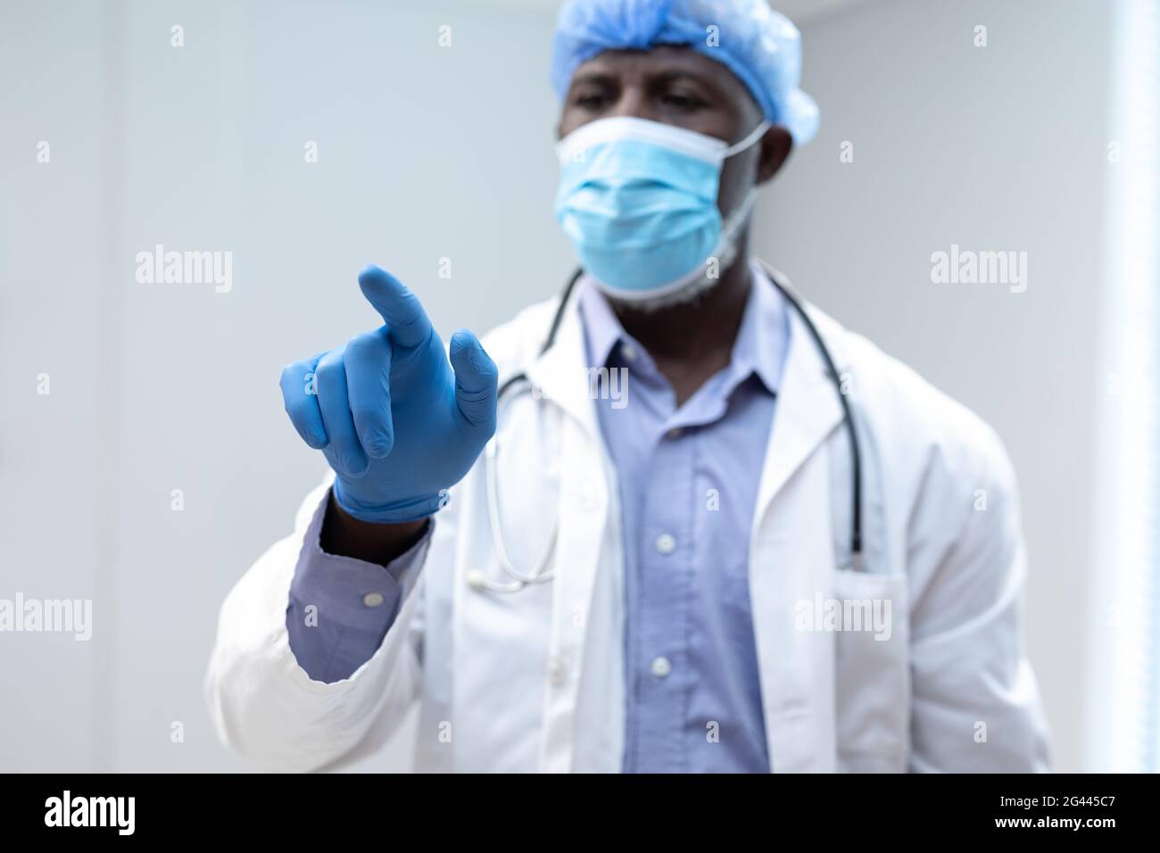 African american male doctor wearing face mask using virtual ...
