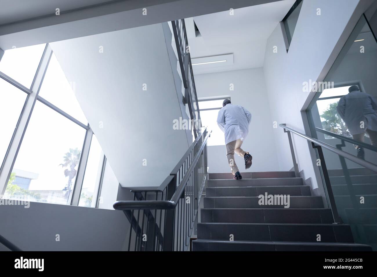 Senior african american male doctor wearing lab coat running up stairs ...