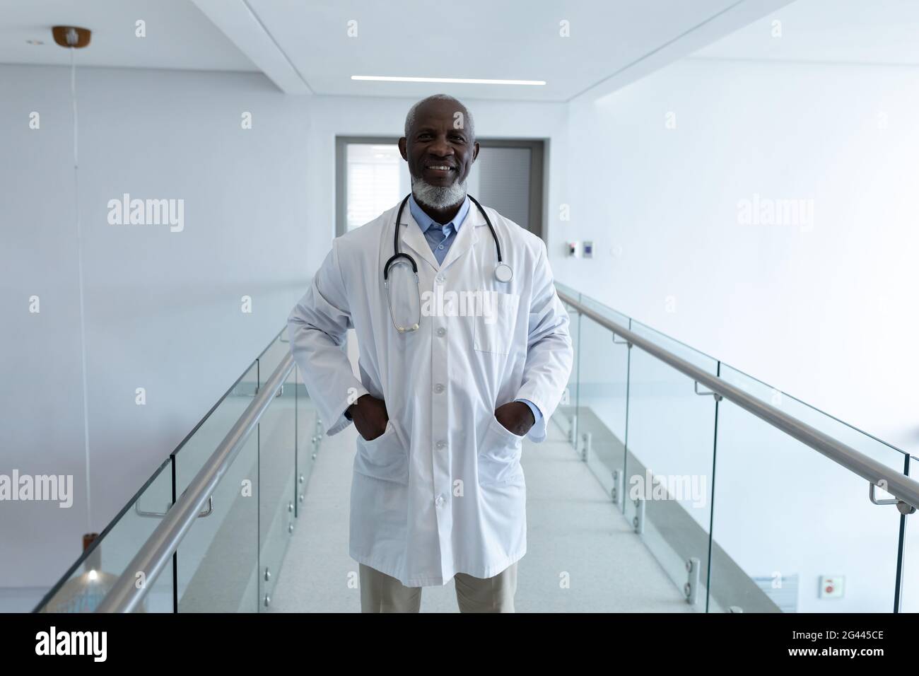 Portrait of african american male doctor standing in hospital corridor ...