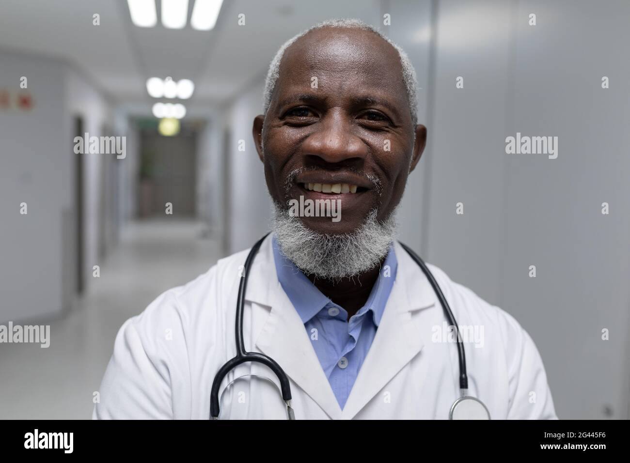 Portrait of smiling senior male doctor with stethoscope wearing lab ...