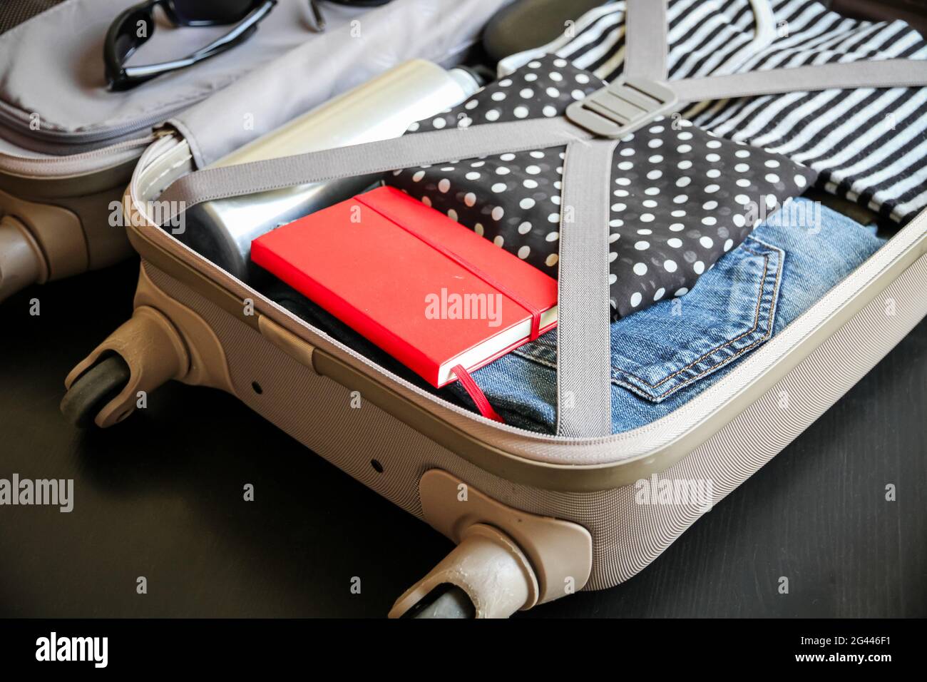 Open suitcase full of clothes isolated on black background Stock Photo ...