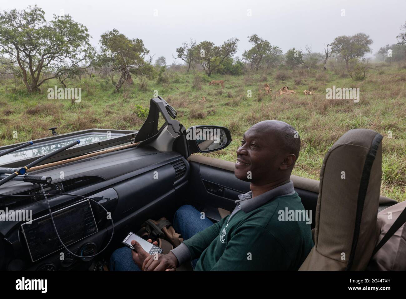 Portrait of a smiling Rwandan man in a safari vehicle operated by ...