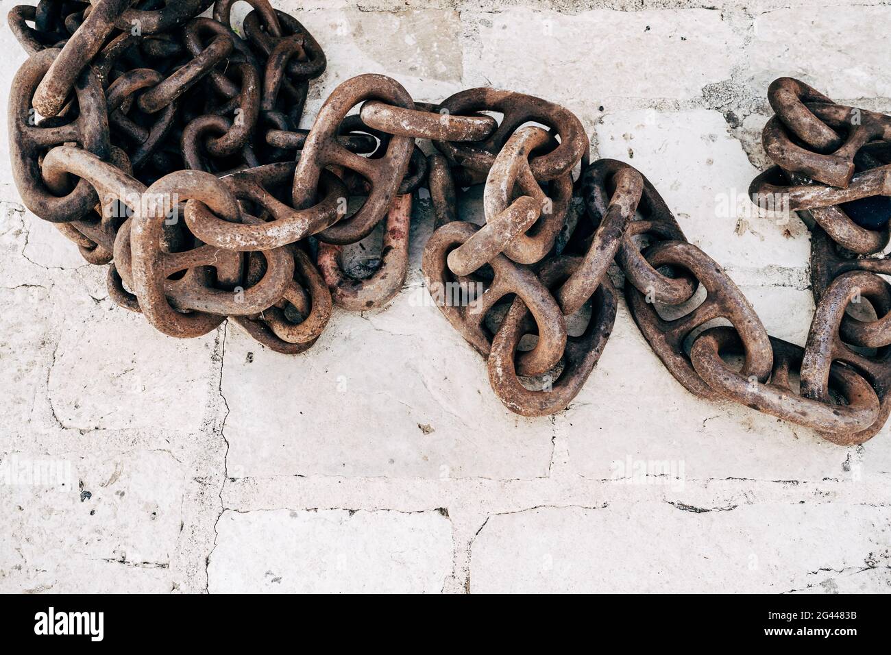Old rusty chain on a stone background. Several links of a rusty old ...