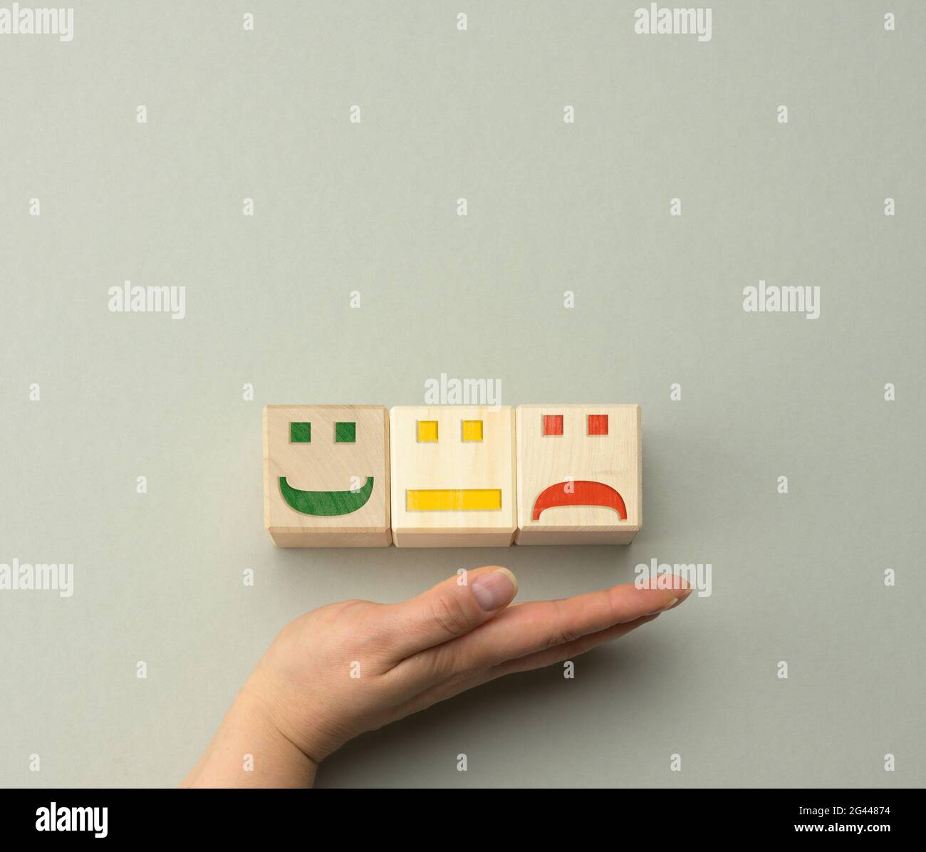 Wooden blocks with different emotions from smile to sadness and a woman ...