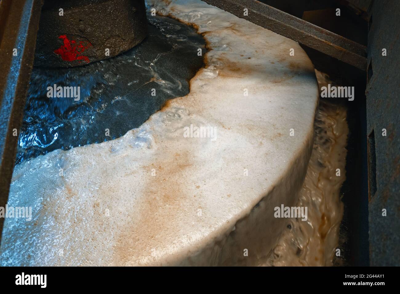 Flotation machine. A stream of gray, dirty foam flows from the ...