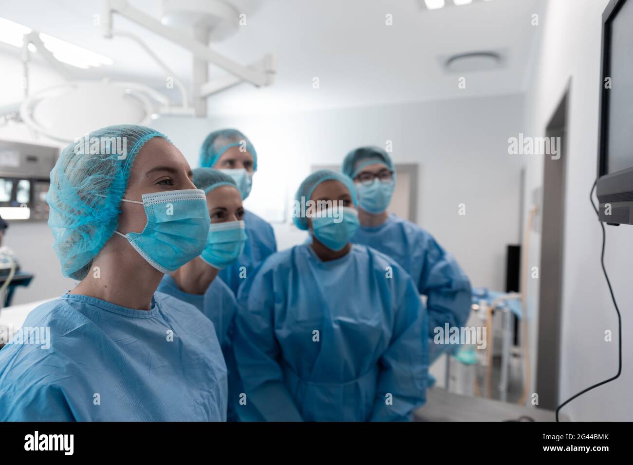 Diverse group of male and female surgeons in operating theatre wearing ...
