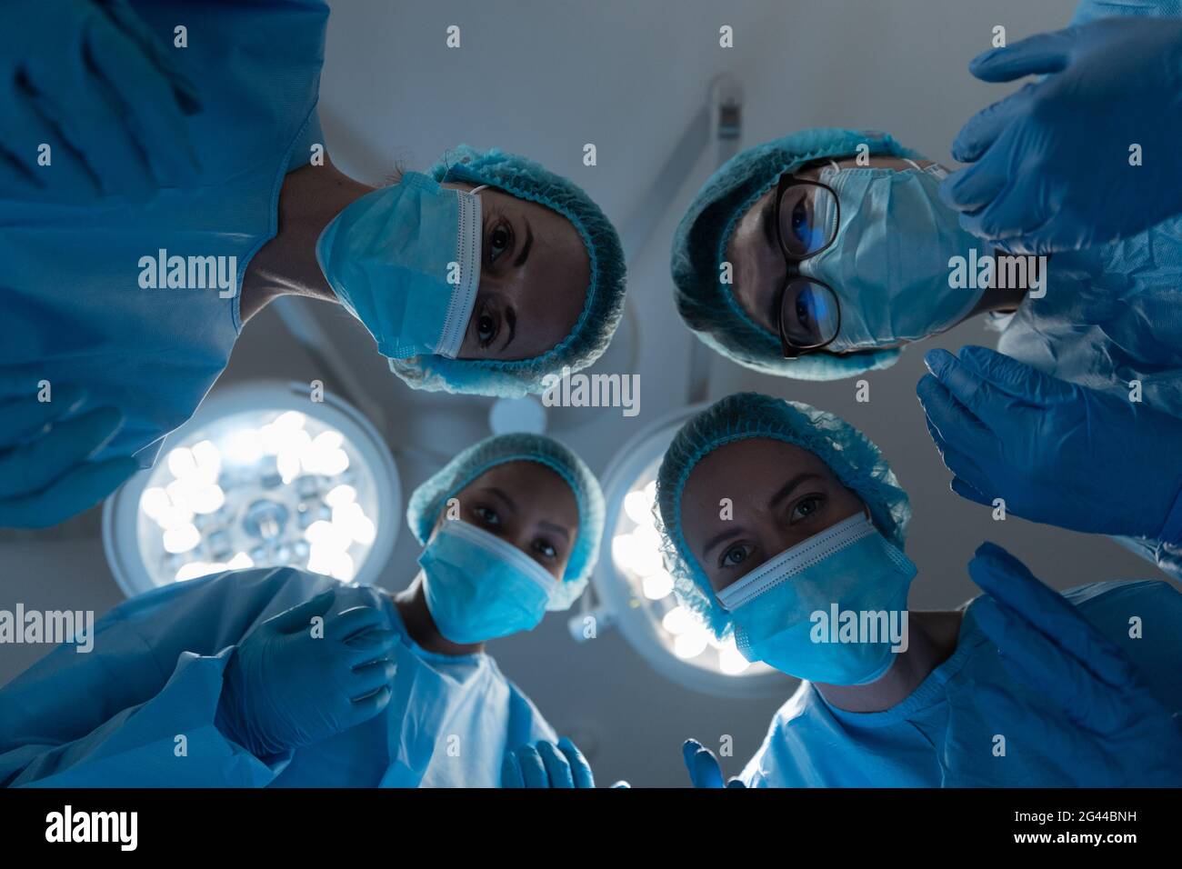 Diverse group of male and female surgeons in operating theatre wearing ...