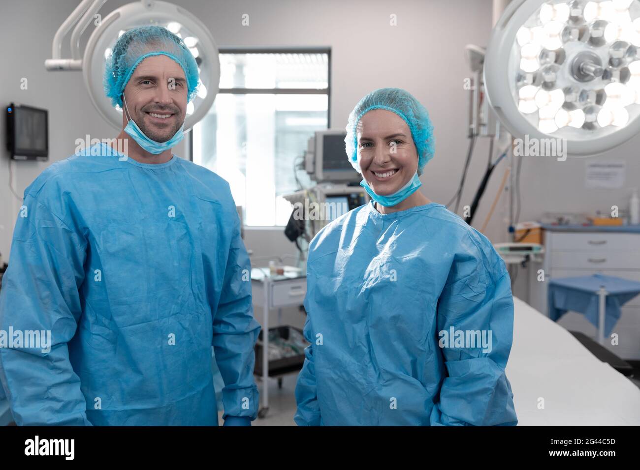 Portrait of caucasian male and female surgeons standing in operating ...