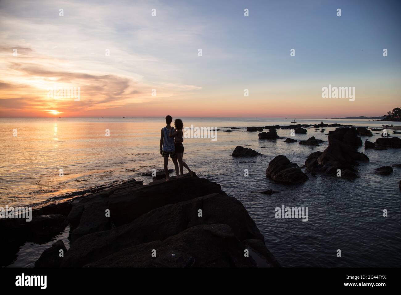 Silhouette of young couple on rocks at Ong Lang Beach at sunset, Ong ...