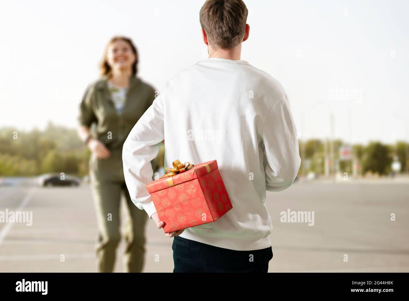 holding a gift box behind the back to male a surprise present Stock ...