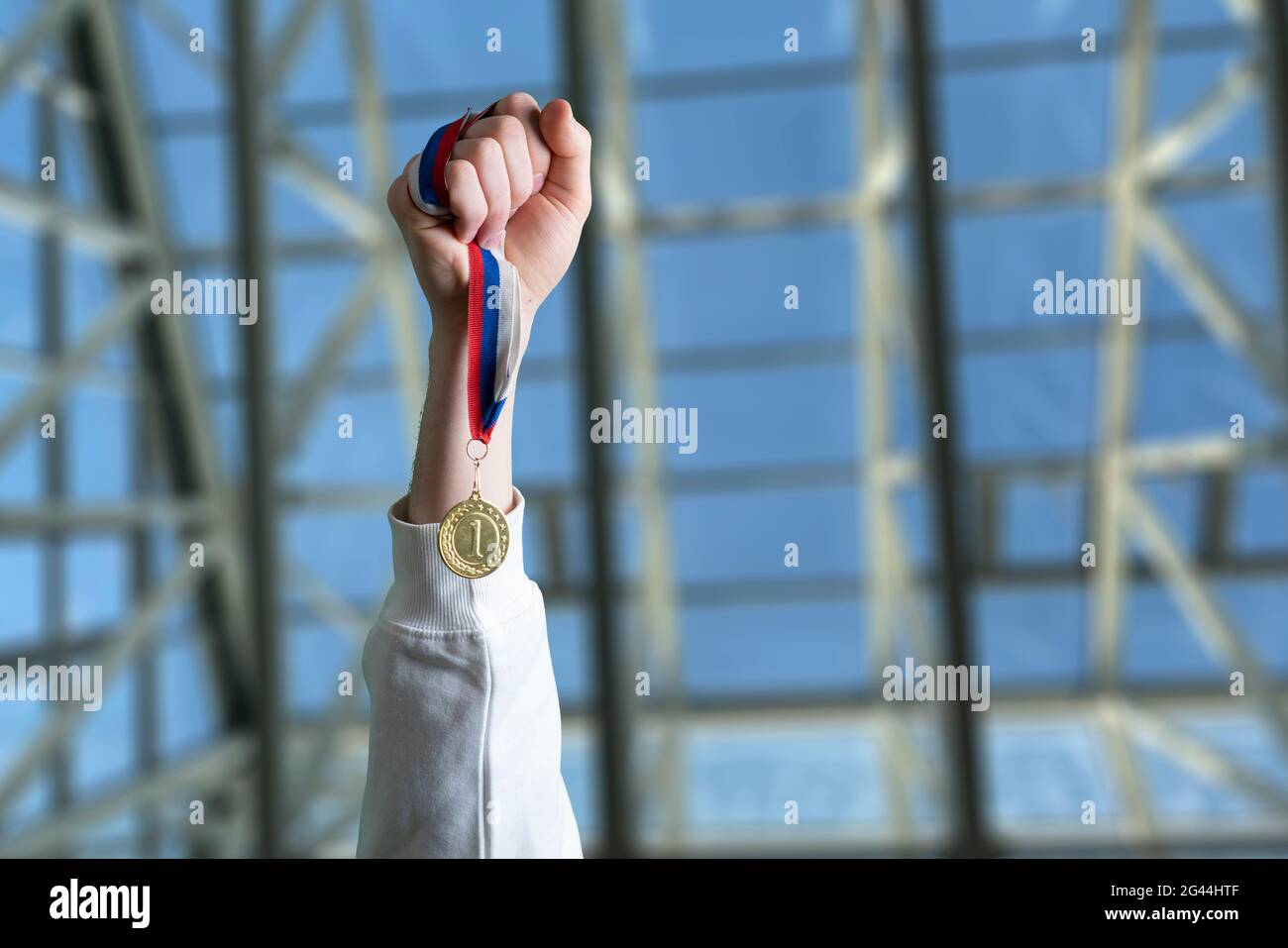 person raised hand winning the first place, hand hold gold medal Stock ...