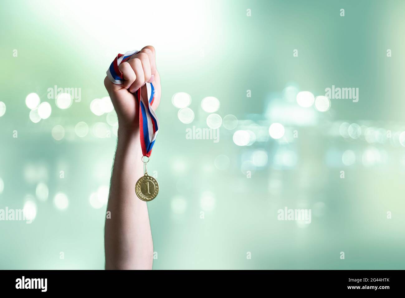 person raised hand winning the first place, hand hold gold medal Stock ...