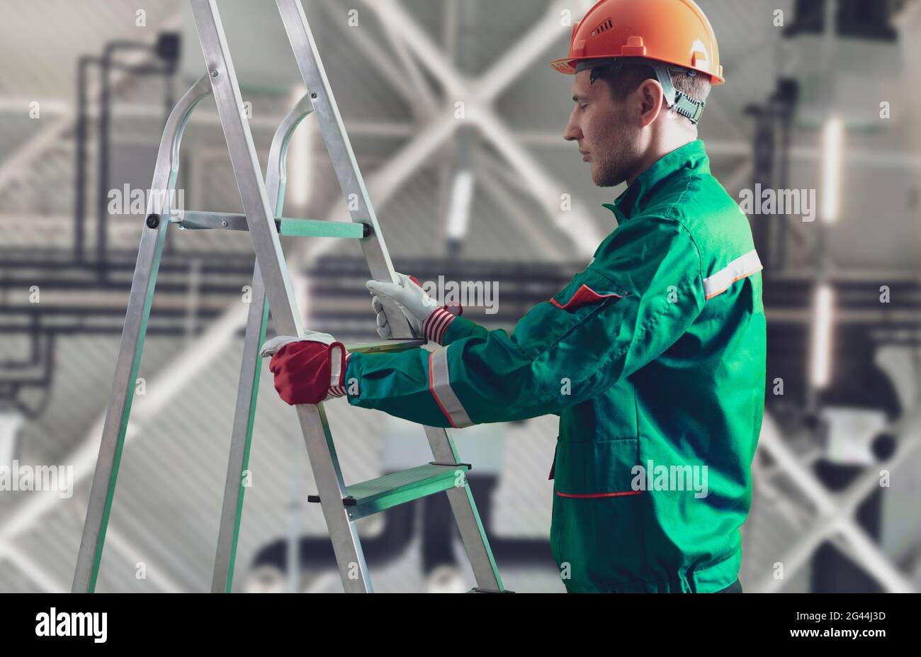 male worker on construction site holding and carrying the ladder Stock ...