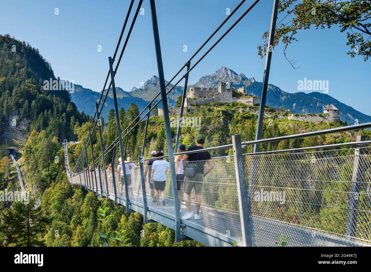 Several people walk over the Highline 179 rope bridge with Ehrenberg ...