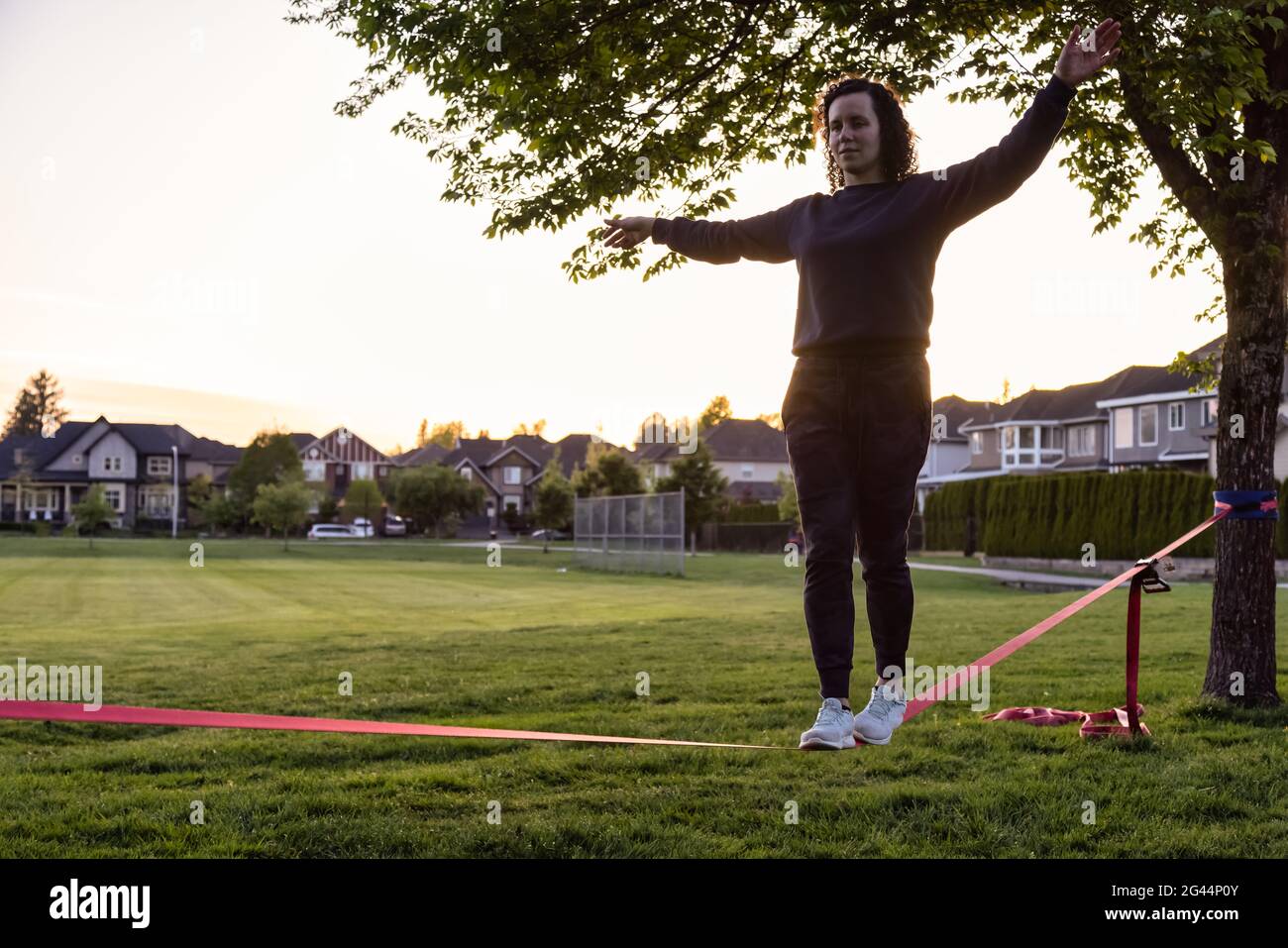 Adventurous White Caucasian Adult Woman walking on a Slackline Stock ...