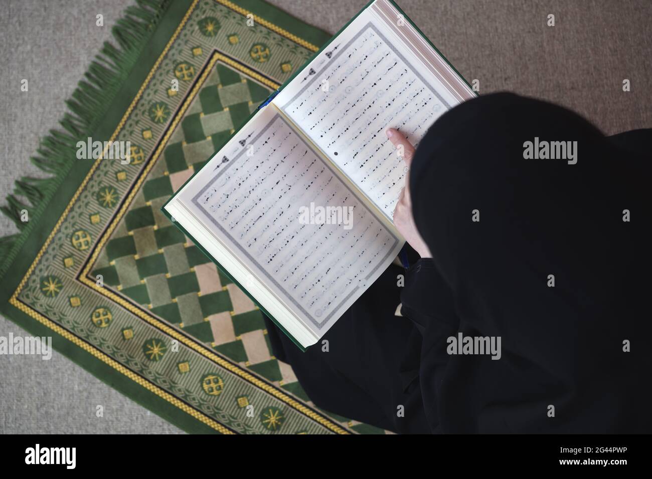 Middle eastern woman praying and reading the holy Quran Stock Photo - Alamy