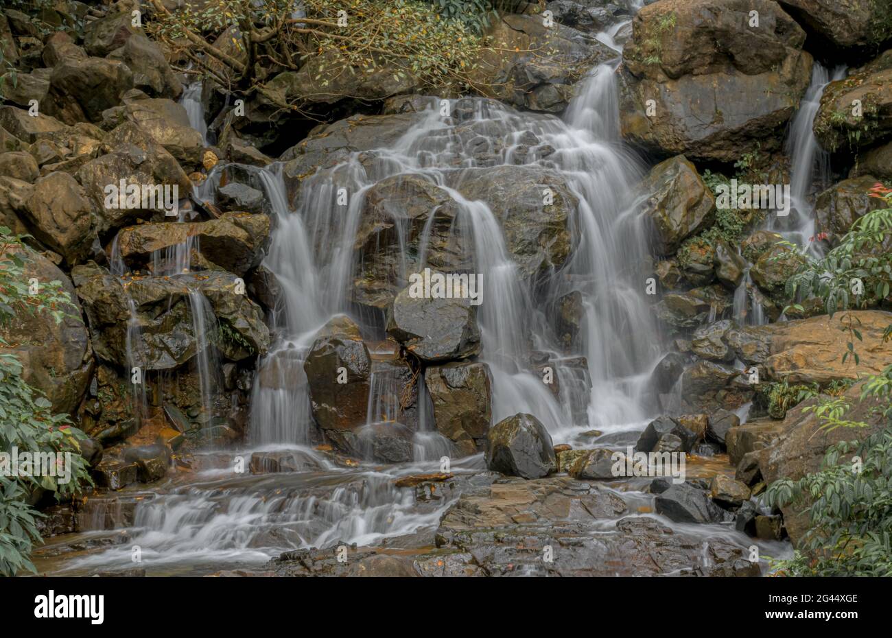 Long exposure shot of hidden natural waterfall situated at secluded and ...