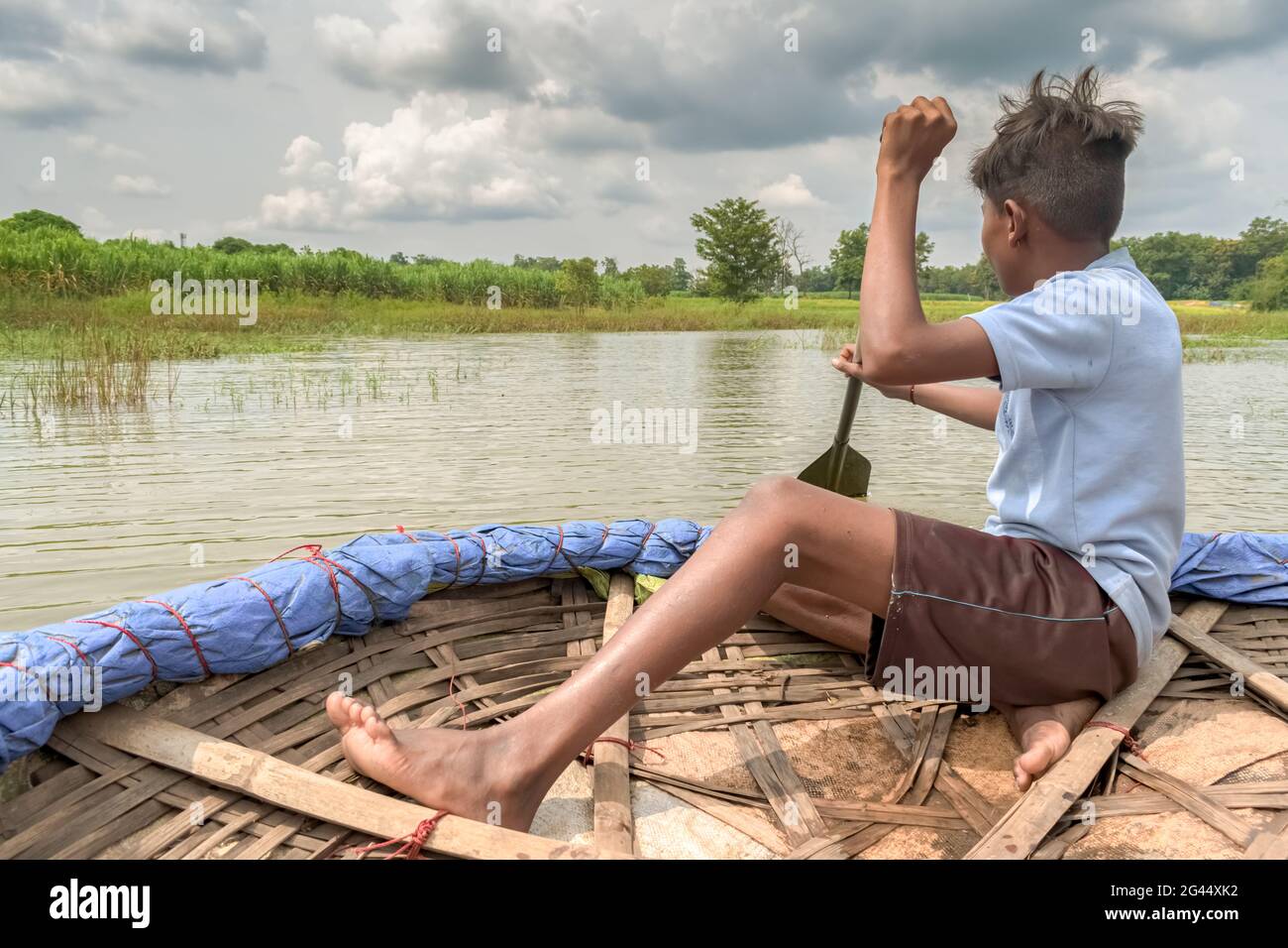 Young teenage boy, a villager rowing traditional coracle, to cross ...