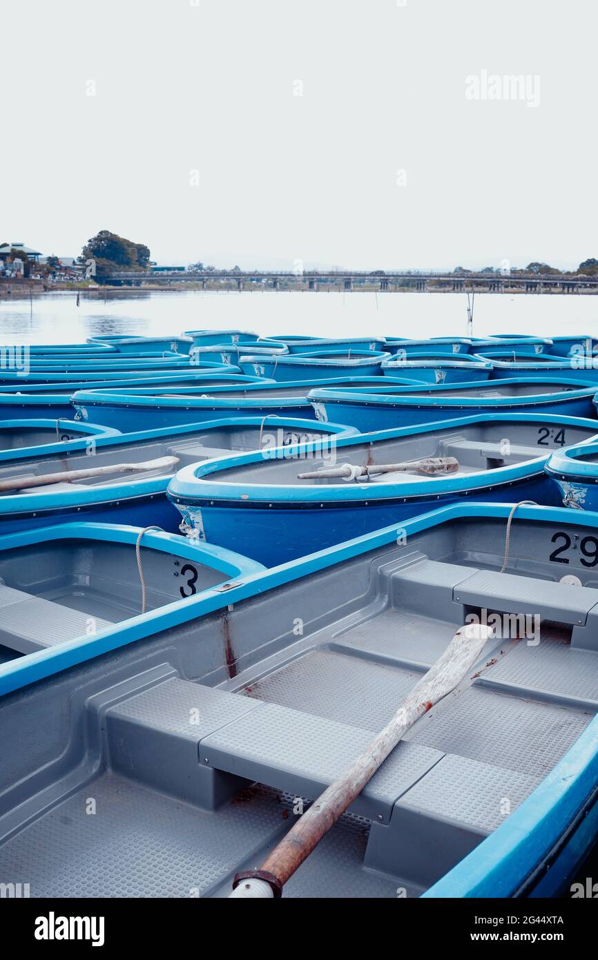 Rowing boats for tourists stand ready by the river in Kyoto, Japan ...