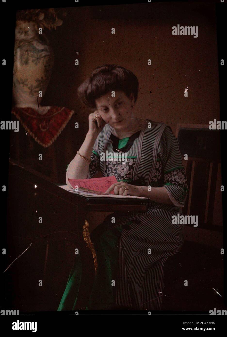 Woman behind reading table. Young woman sitting behind a reading table ...