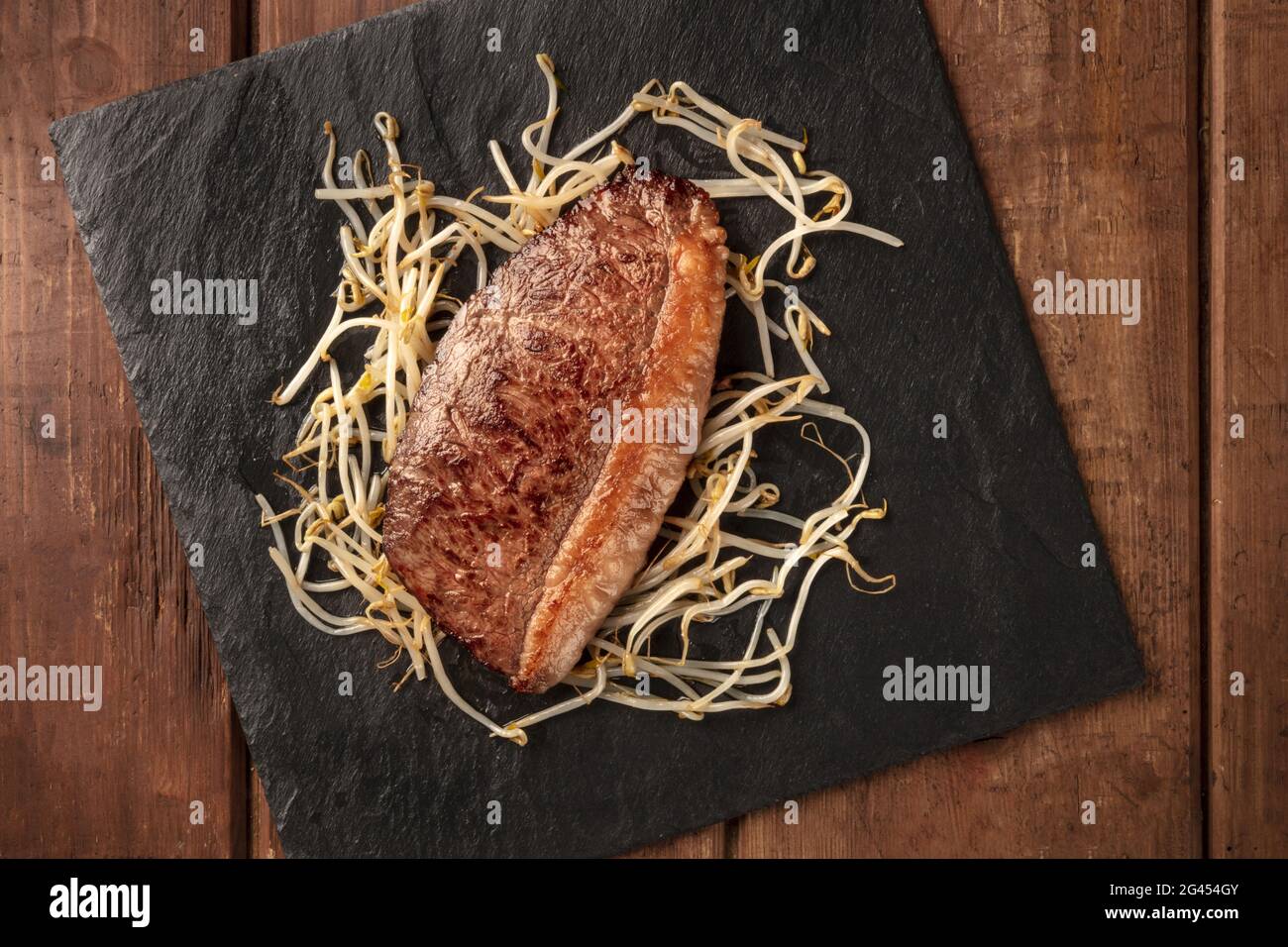 Kobe meat, wagyu beef steak, cooked, with soy bean sprouts, shot from ...