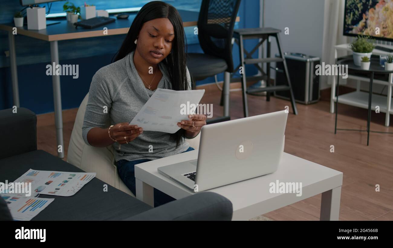 African american student analyzing financial paperwork graph typing ...