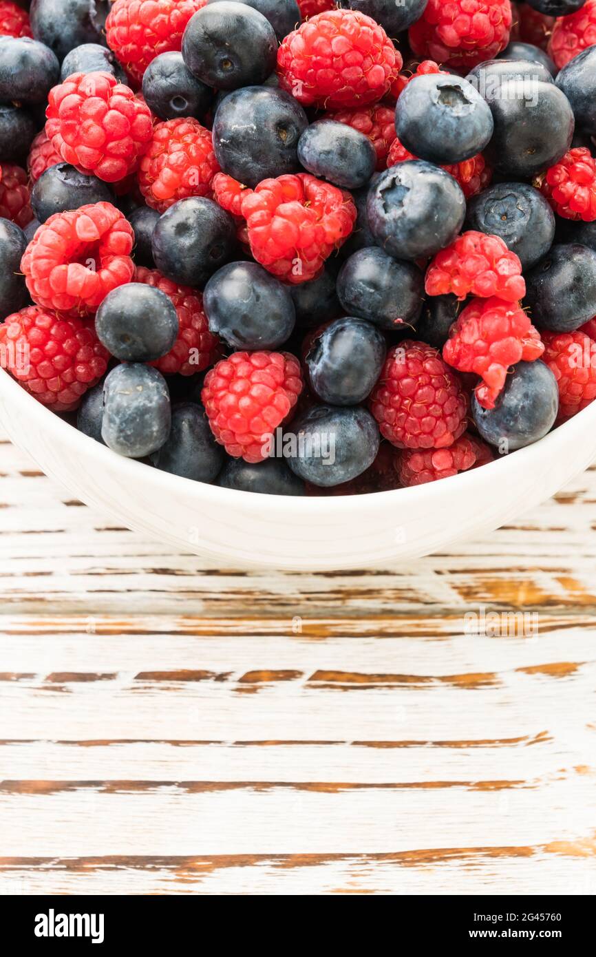 Group of Blueberry and Rasberry fruit in bowl on wooden background ...