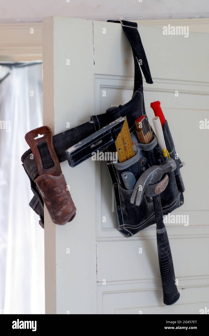Tool belt hanging on a door side Stock Photo - Alamy