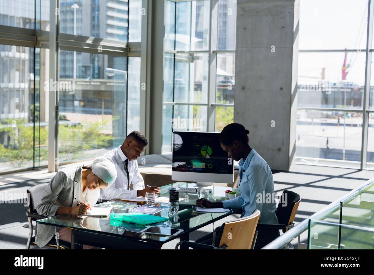 Male and females executives working together at desk Stock Photo - Alamy