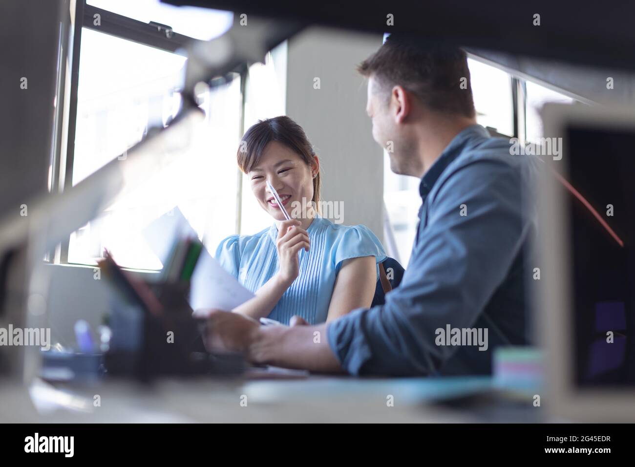 Two young professionals sitting desk hi-res stock photography and ...