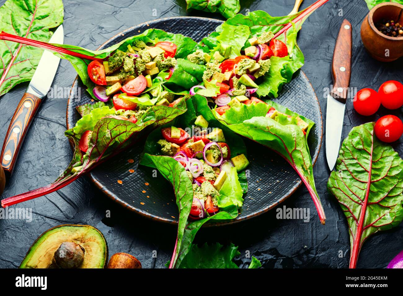 Avocado salad, tomato with garlic sauce in chard leaves.Summer vitamin ...