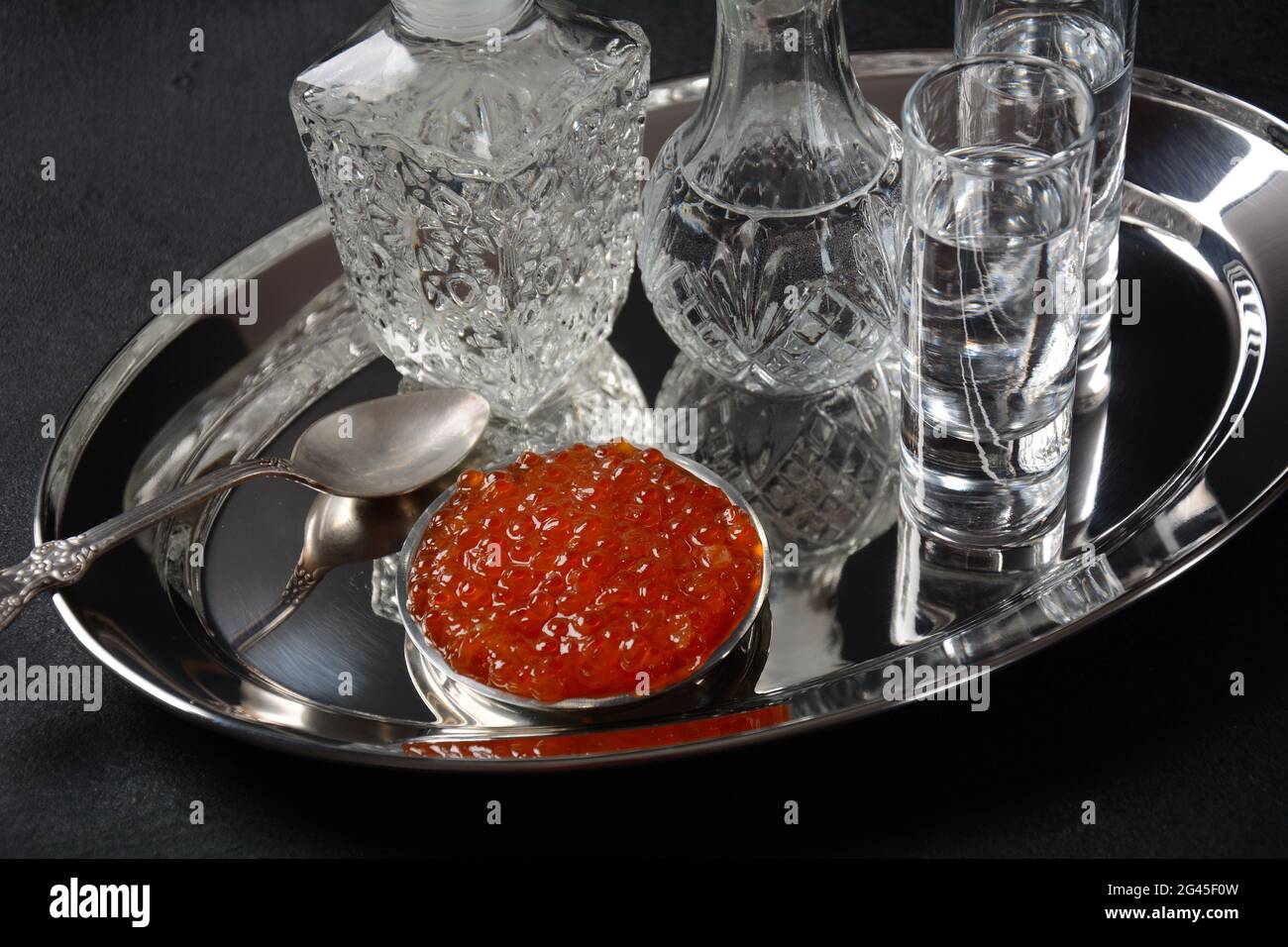 Red caviar in bowl on silver tray on black background with vodka Stock ...