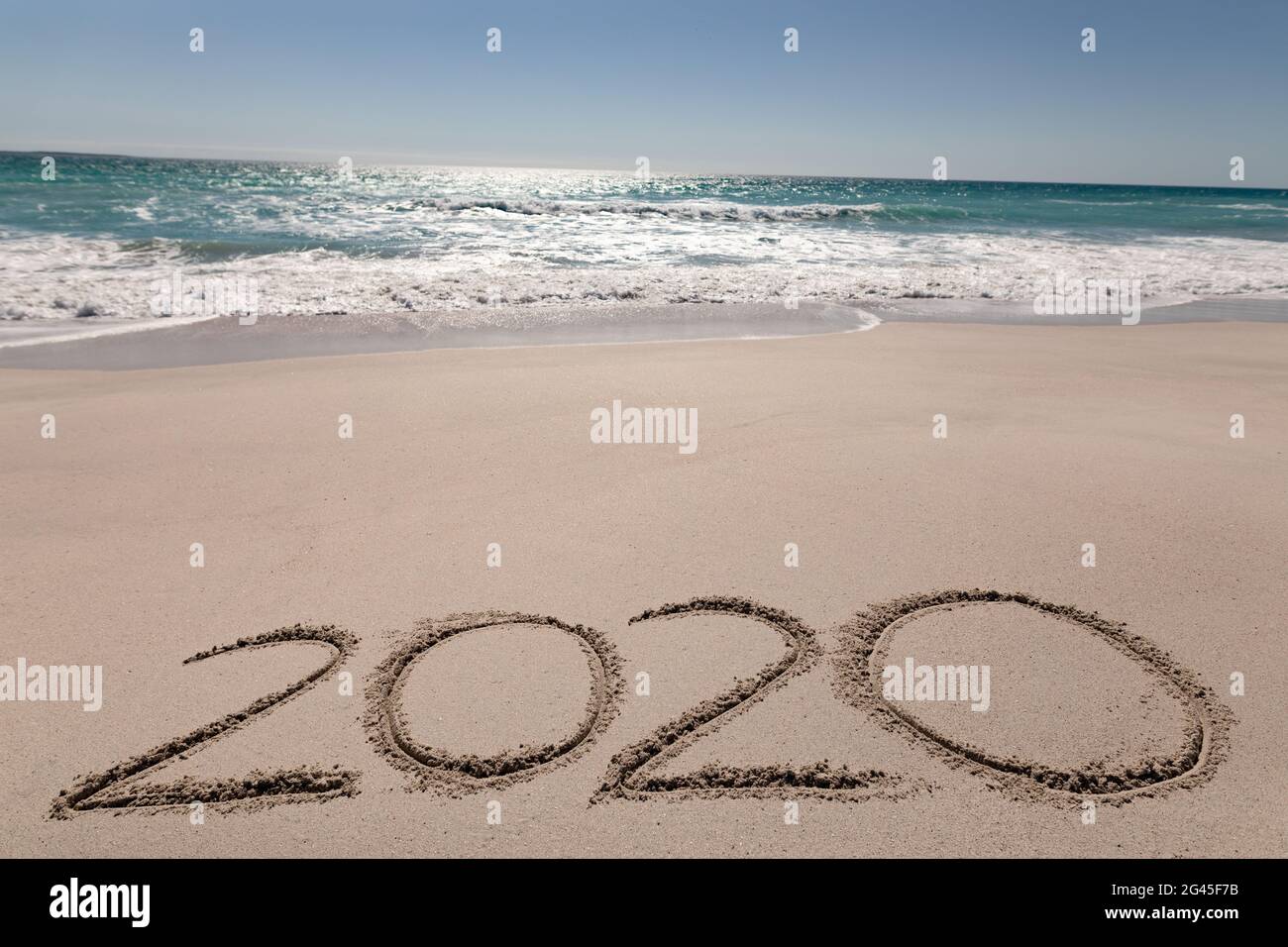 Beach holiday with 2020 in the sand Stock Photo - Alamy