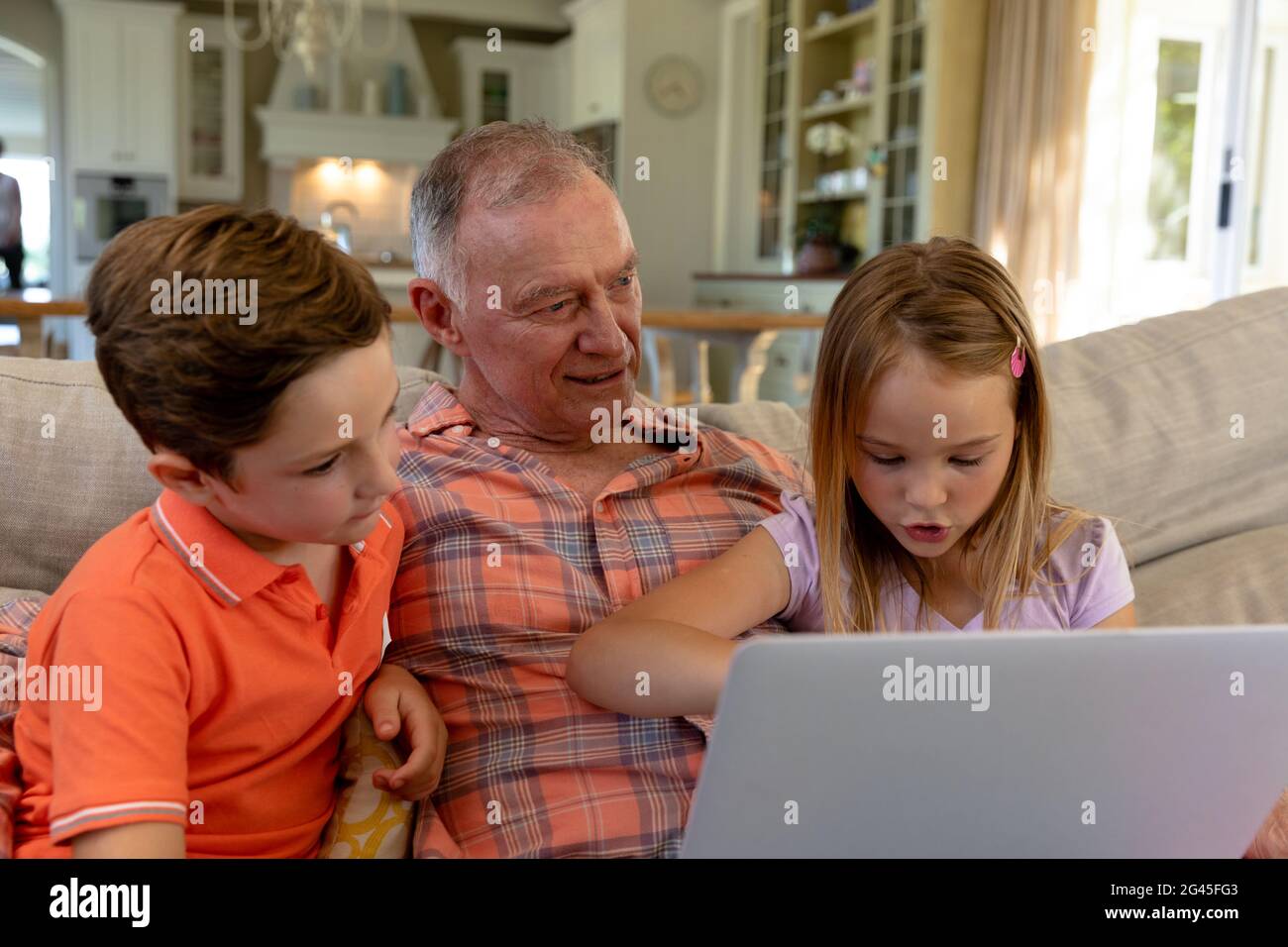 Grandfather and grandchildren at home in the living room Stock Photo ...