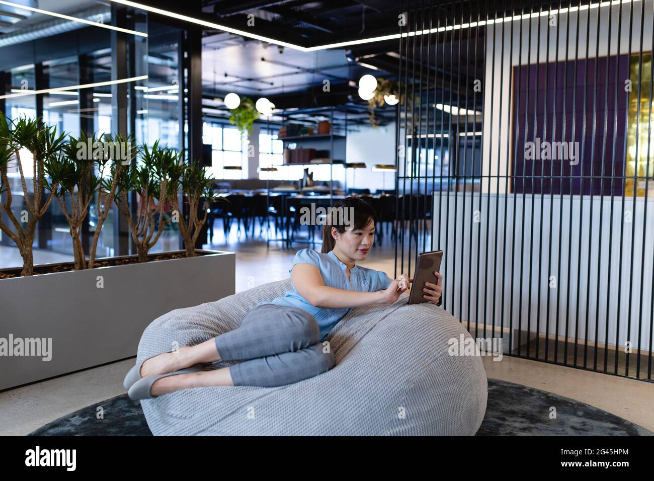 Asian woman using her phone in a bean bag Stock Photo - Alamy