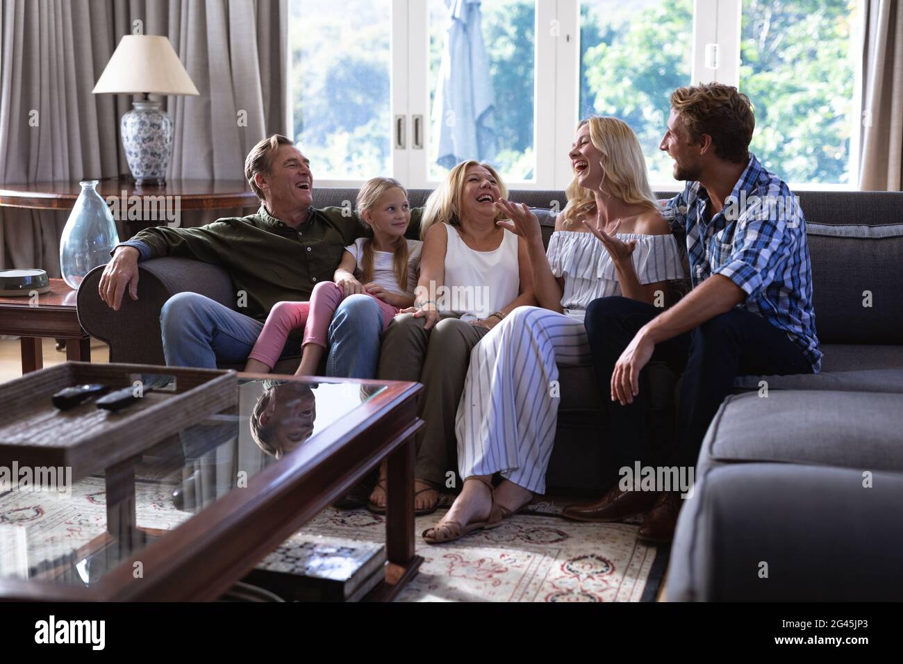 Multi-generation Caucasian family sitting on a couch together Stock ...