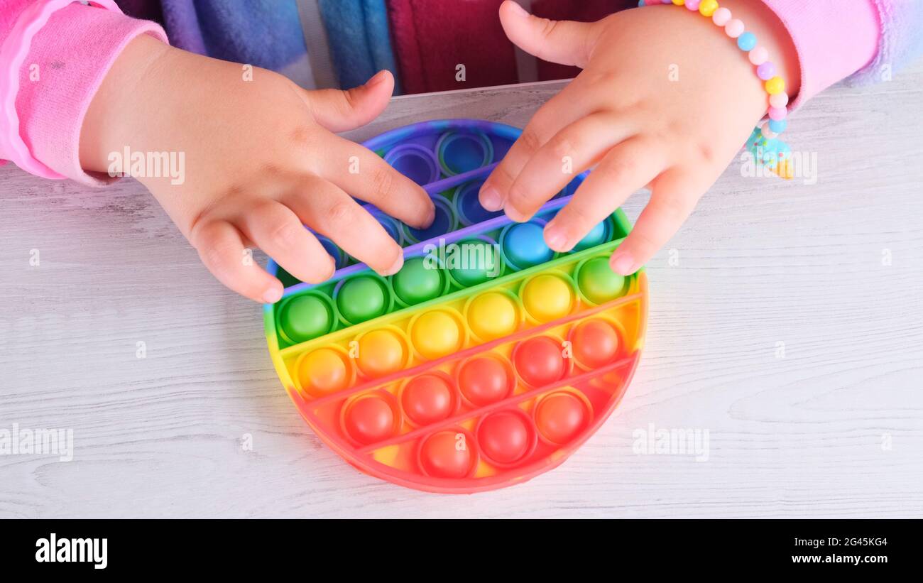 baby female hands playing with pop it sensory toy circle form. little ...